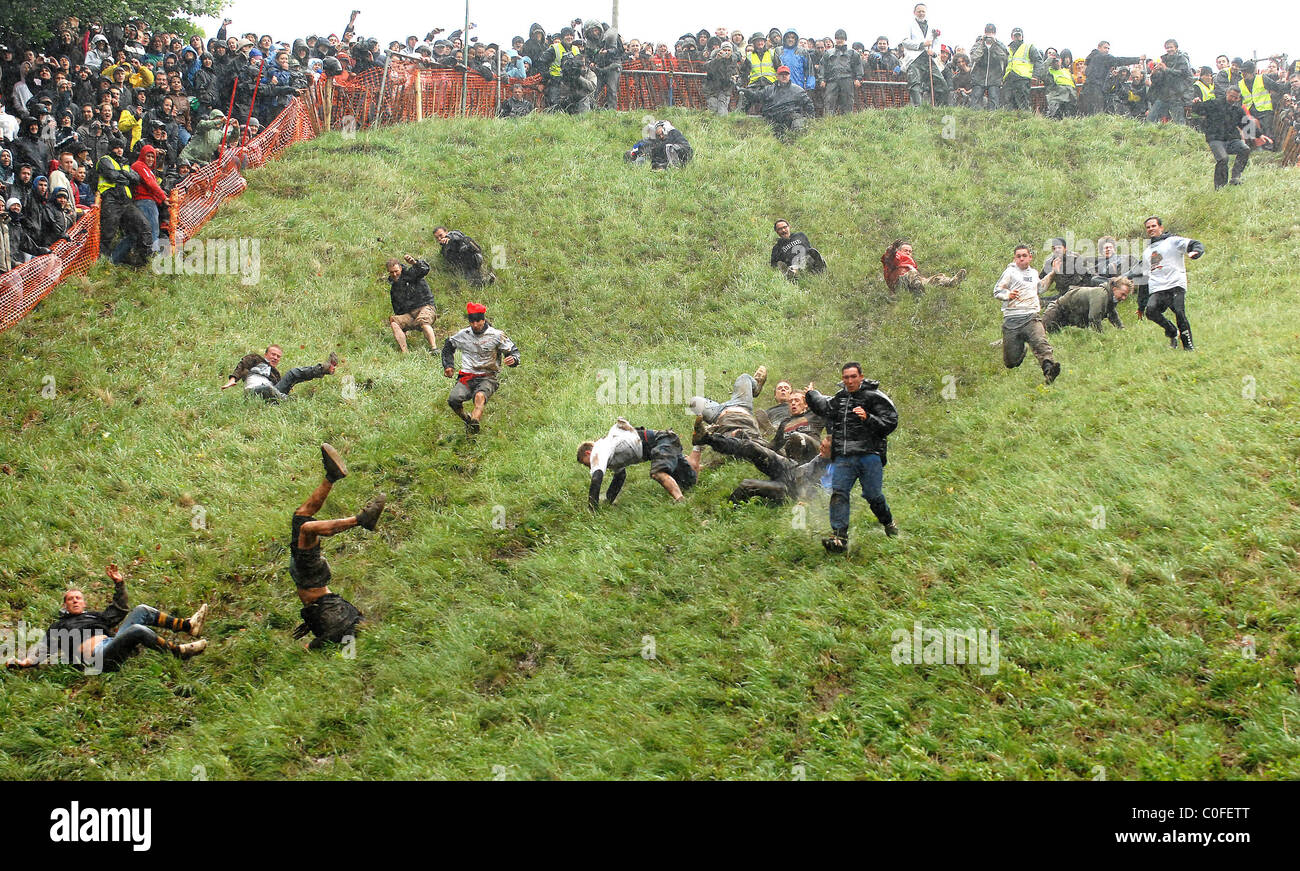 Competitors chase a Double Gloucester Cheese down the steep gradient of ...