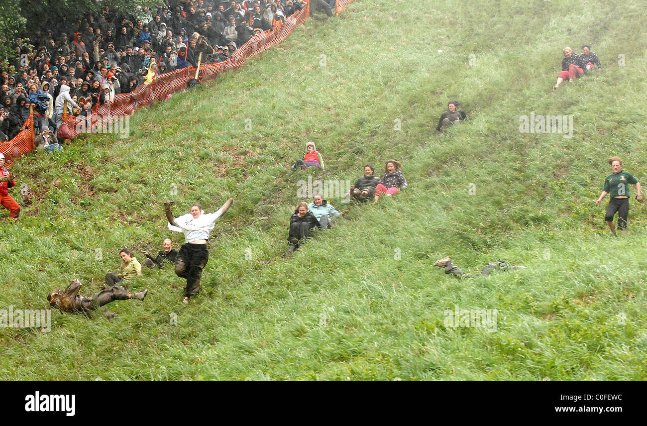 Competitors chase a Double Gloucester Cheese down the steep gradient of ...