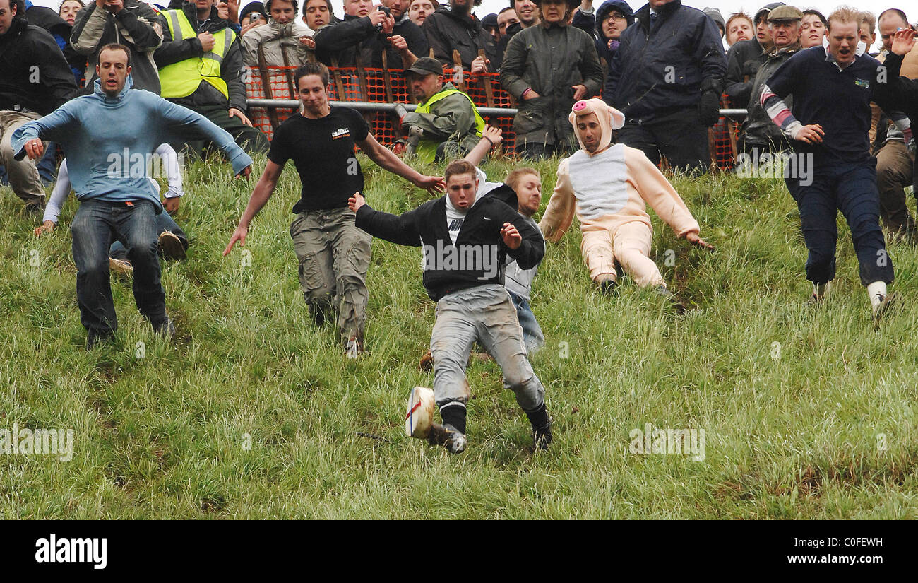 Competitors chase a Double Gloucester Cheese down the steep gradient of ...