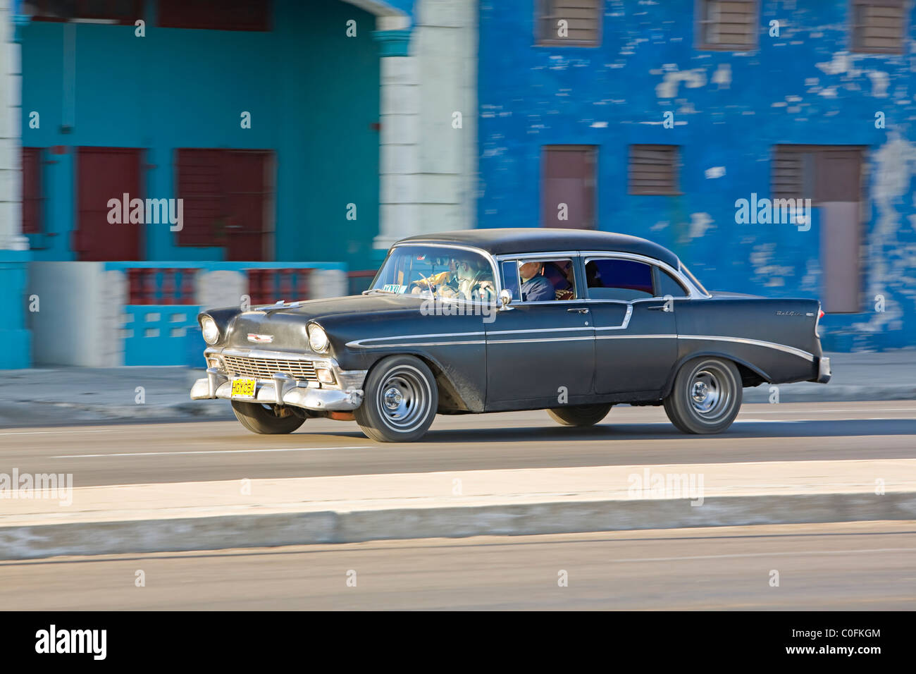 An old American 1950s Chevrolet automobile driving down a street in ...