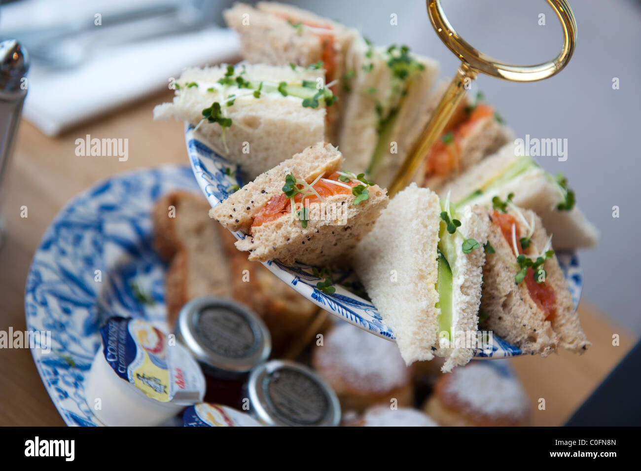 Two-tiered plate of sandwiches and scones in restaurant Stock Photo - Alamy
