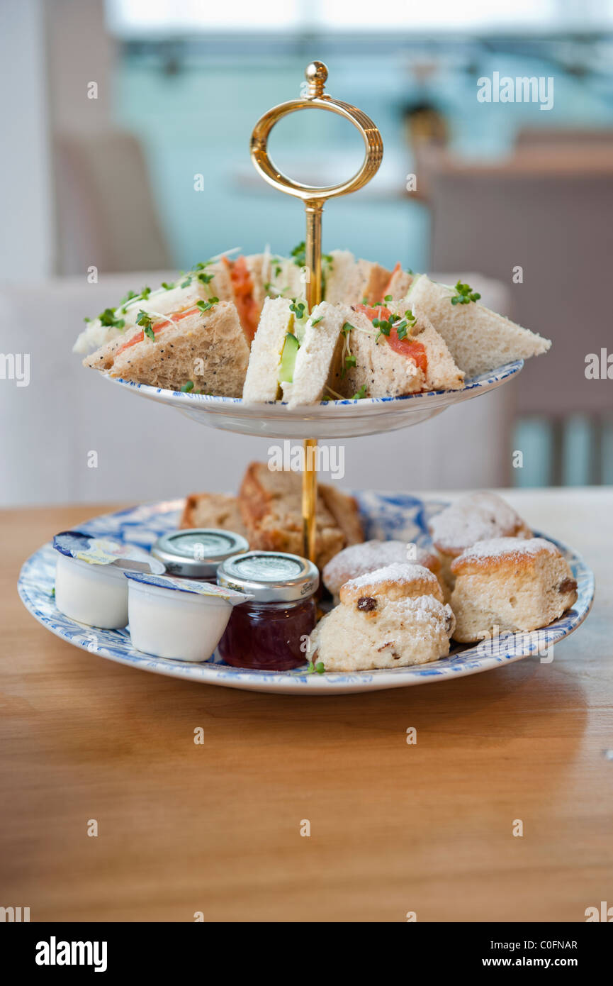 Two-tiered plate of sandwiches and scones in restaurant Stock Photo - Alamy