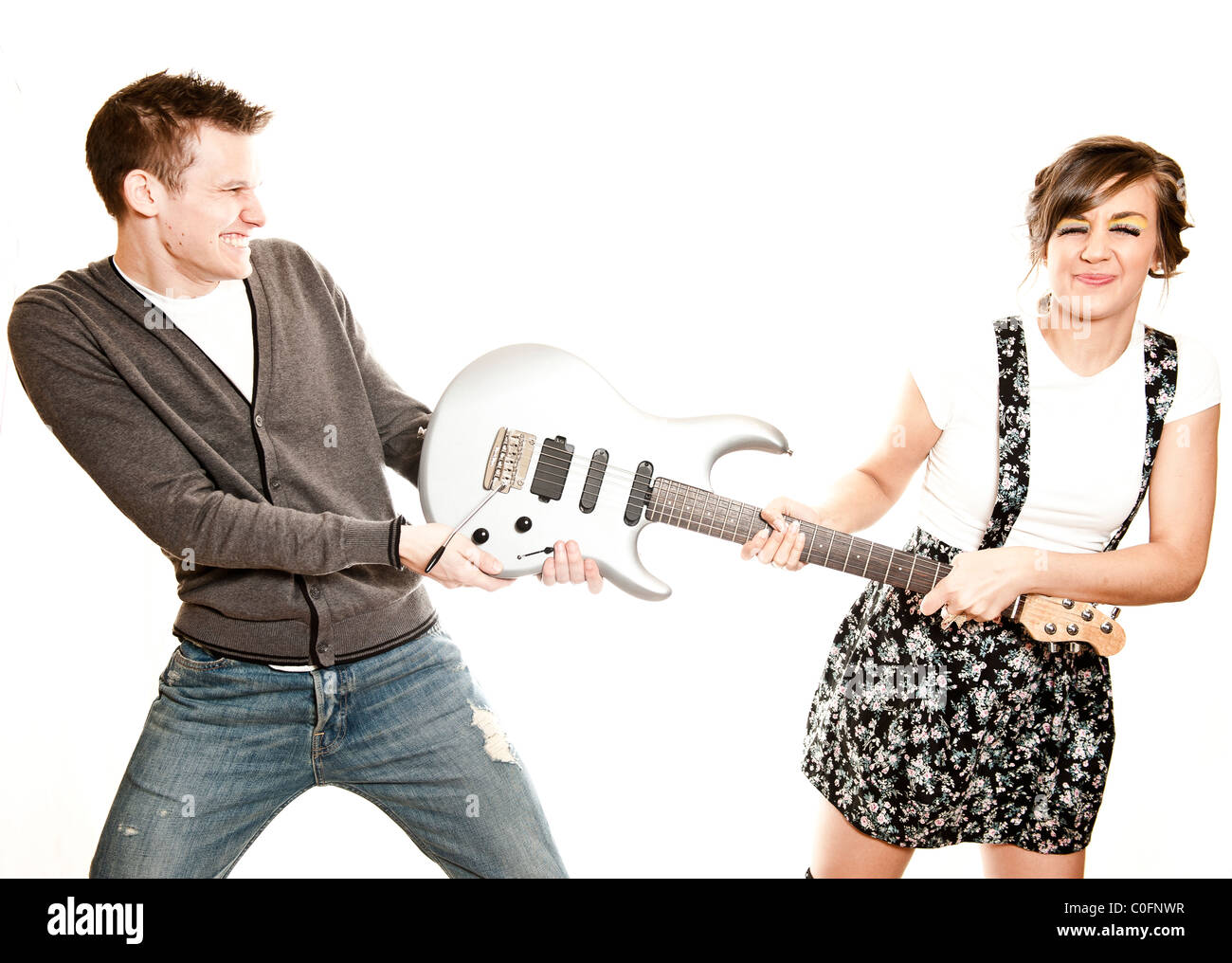 Young girl and guy laughing, fighting over electric guitar Stock Photo ...