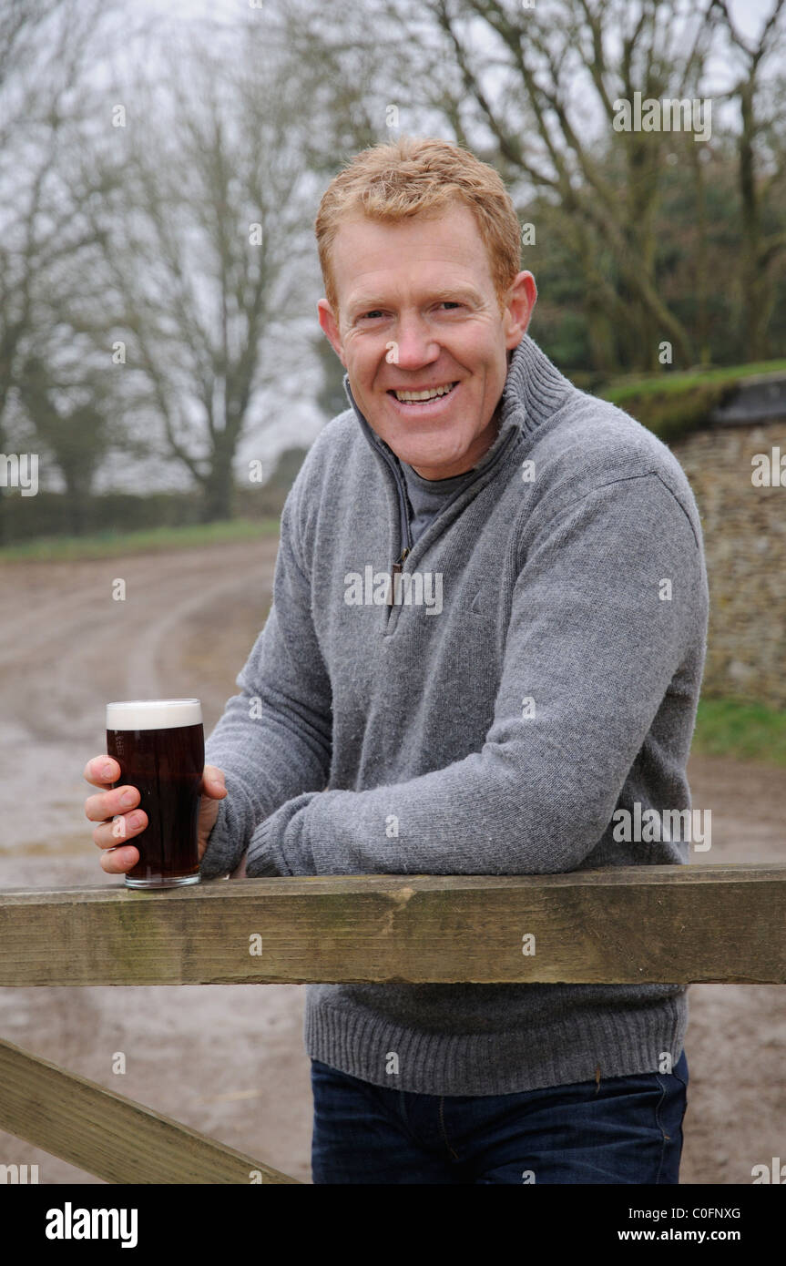 Holding a glass of beer Adam Henson farmer and television presenter at ...