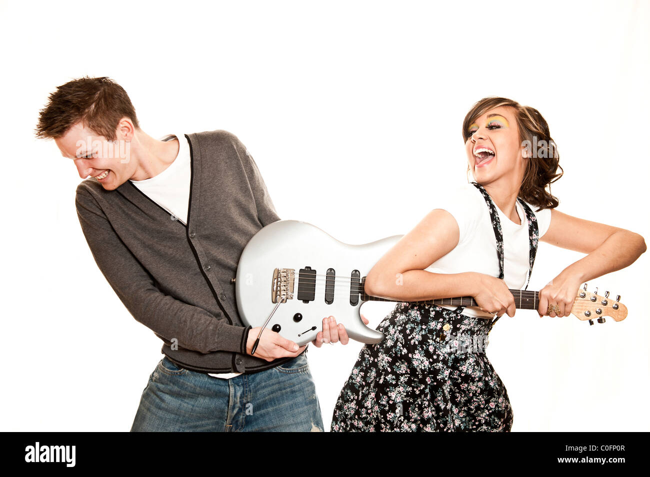 Young girl and guy laughing, fighting over electric guitar Stock Photo ...