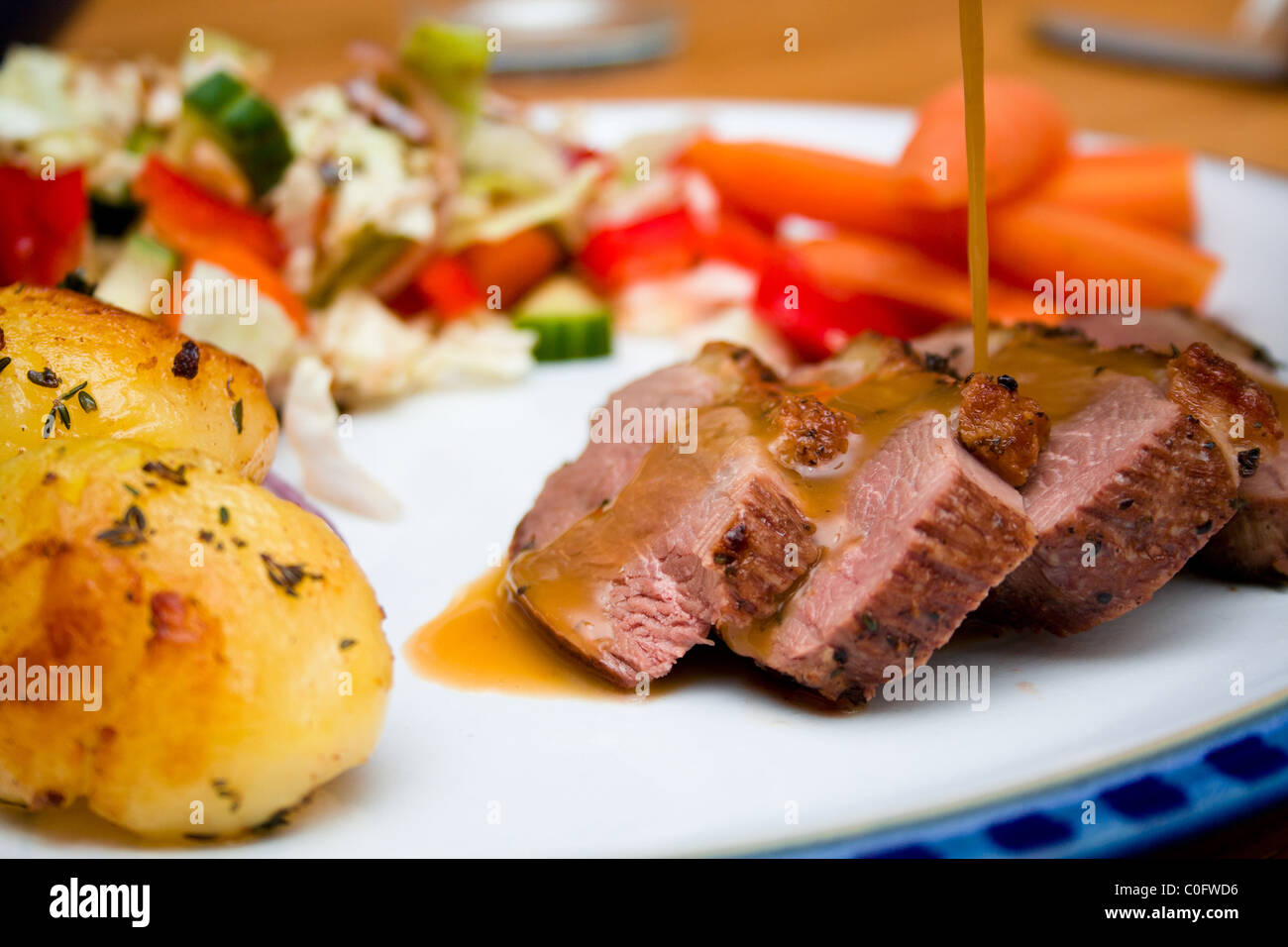 Sauce poured over fillet of lamb Stock Photo - Alamy