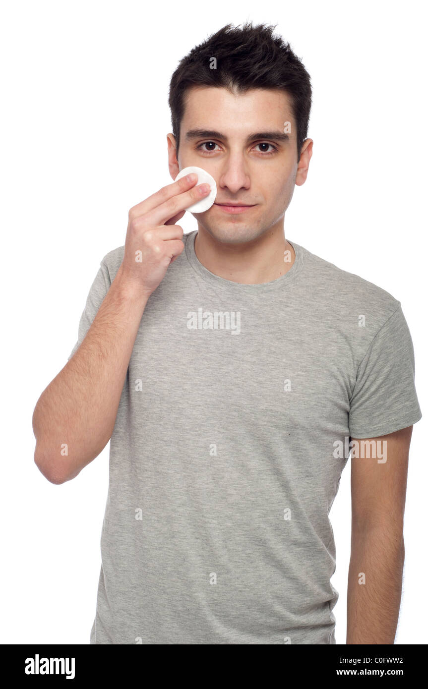handsome young man cleaning face with cotton swab (isolated on white ...