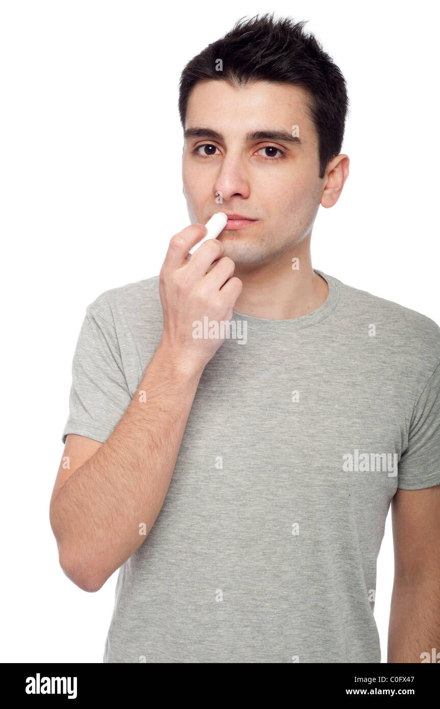 handsome young man applying lip balm (isolated on white background ...