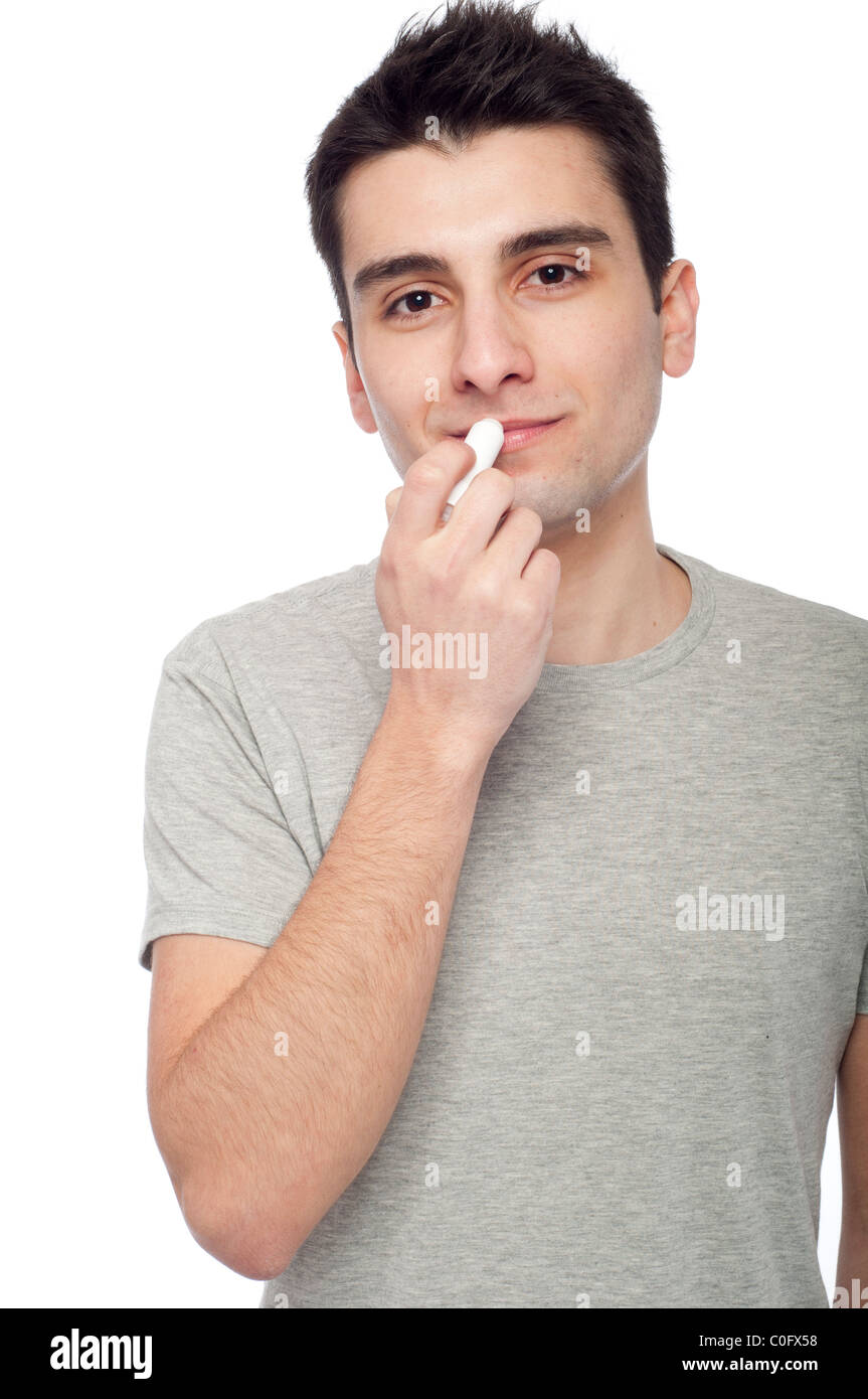handsome young man applying lip balm (isolated on white background ...