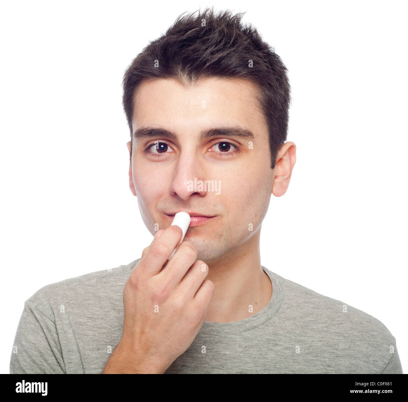 handsome young man applying lip balm (isolated on white background ...