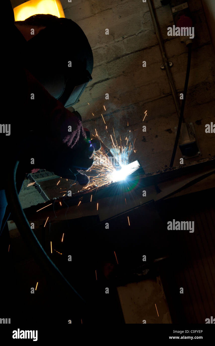 A man wearing protective clothing MIG [metal inert gas] welding Stock ...