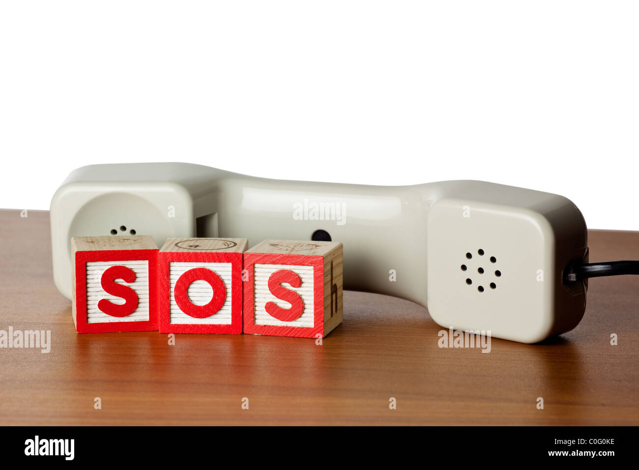 Phone handset with letter blocks SOS on a table Stock Photo - Alamy