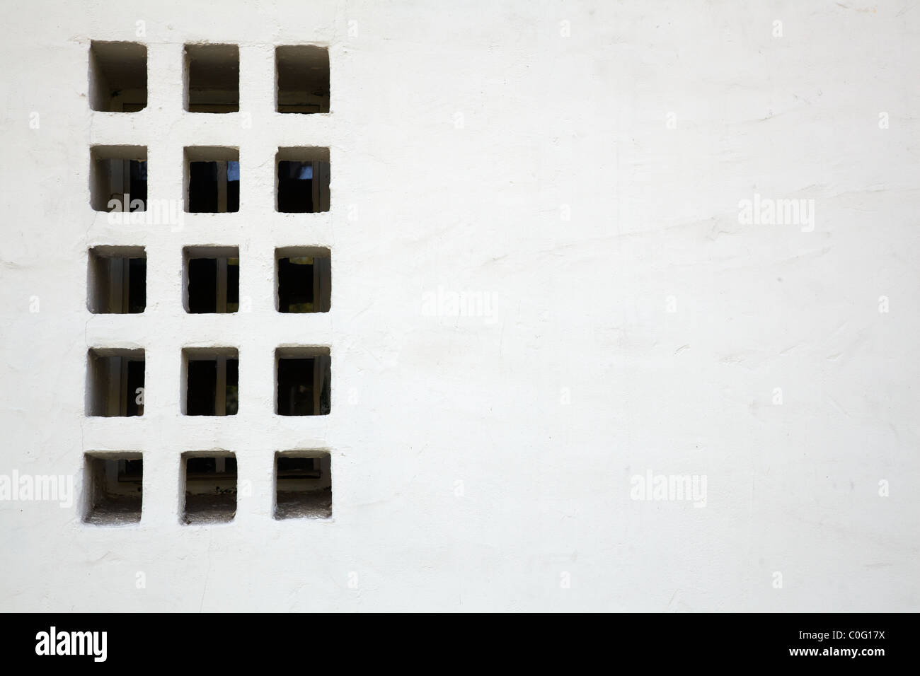 Old Spanish mission style square holes window in beige stucco wall ...