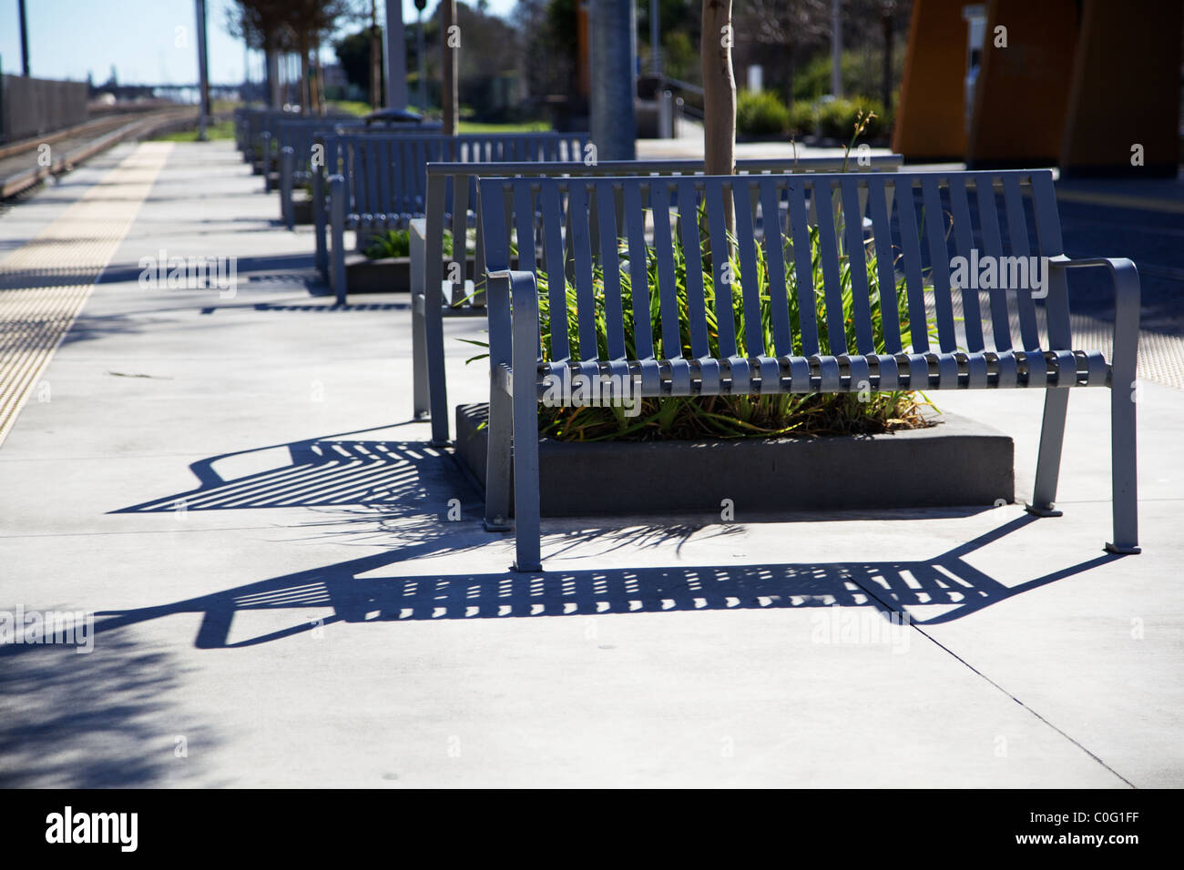 Six Gray metal benches at a Sacramento light rail station diminishing ...