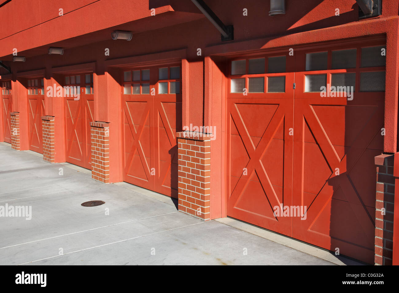 Five red garage doors in perspective as part of an apartment complex ...