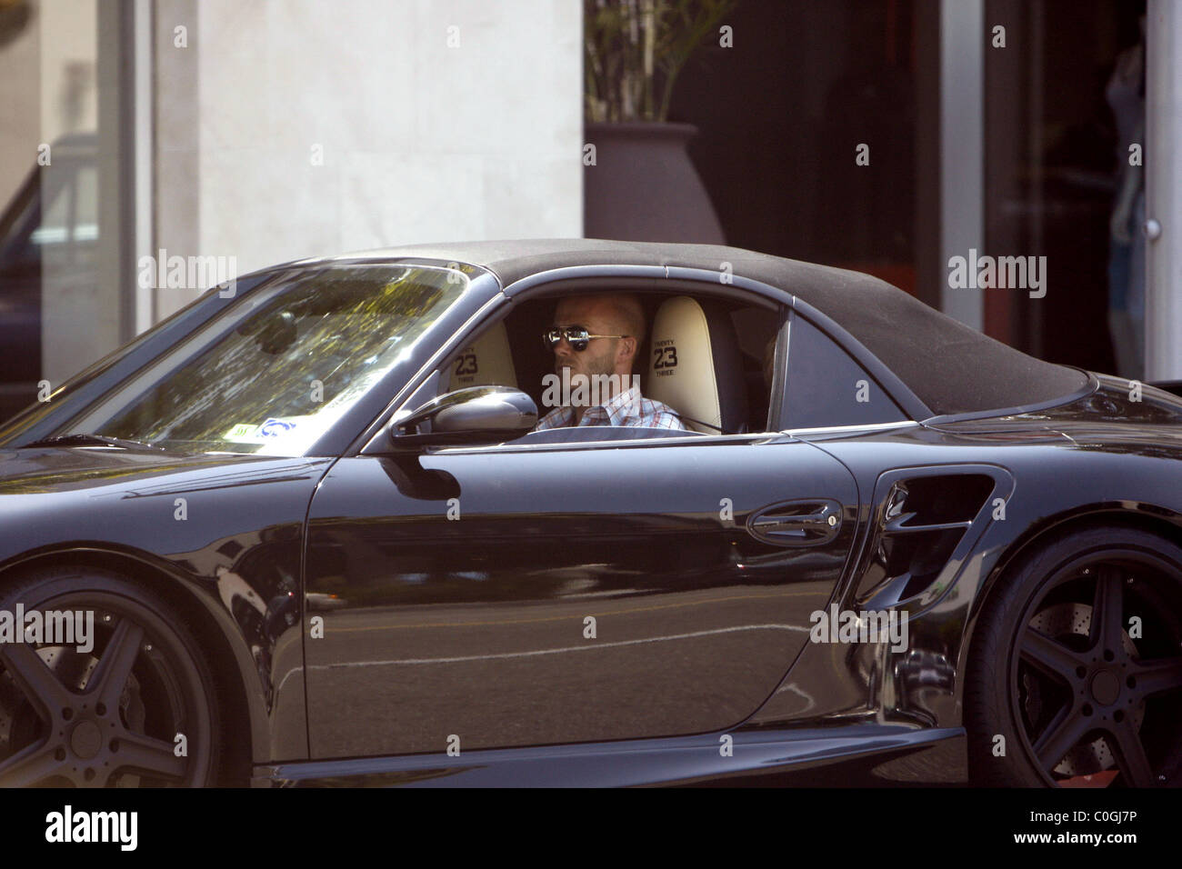 David Beckham waits in his Porsche as his bodyguard fetches him a ...