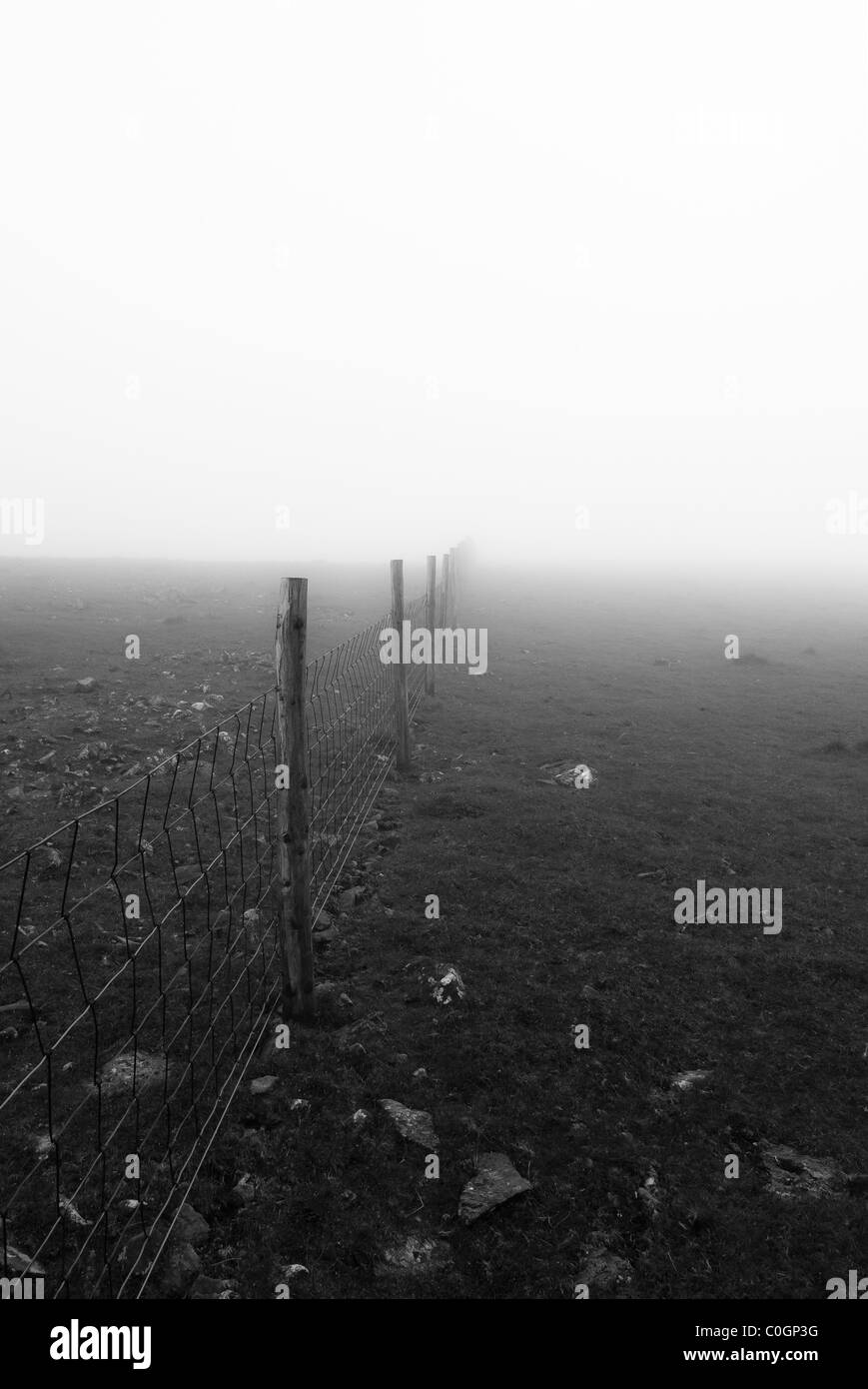 Wire fence disappearing into mist, copyspace Stock Photo - Alamy