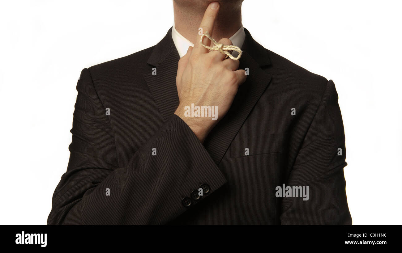 man in buisness suit with a knot around his finger to make him remember ...