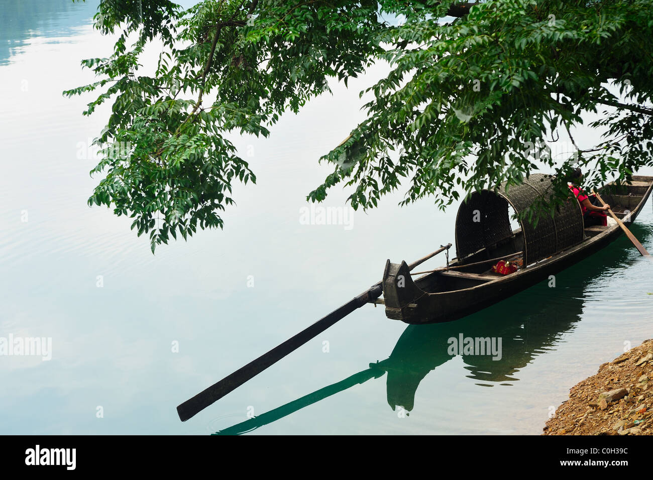 Fishing boat on the river under the tree in Hunan province of China ...