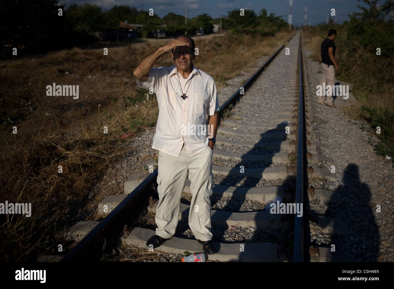 Catholic priest Alejandro Solalinde walks in the railway line in ...