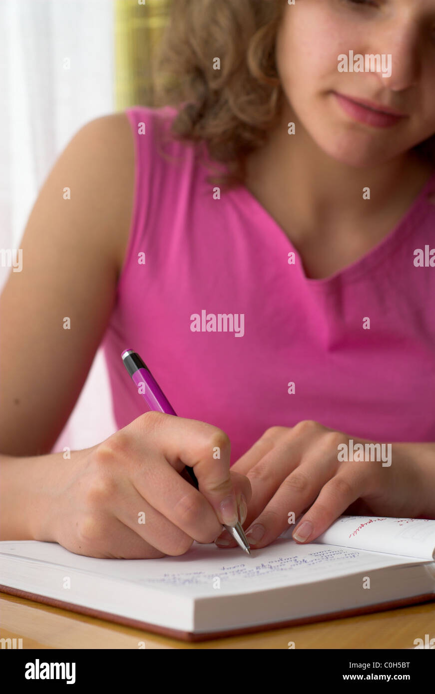 Young female is writing notes and planning her schedule Stock Photo - Alamy