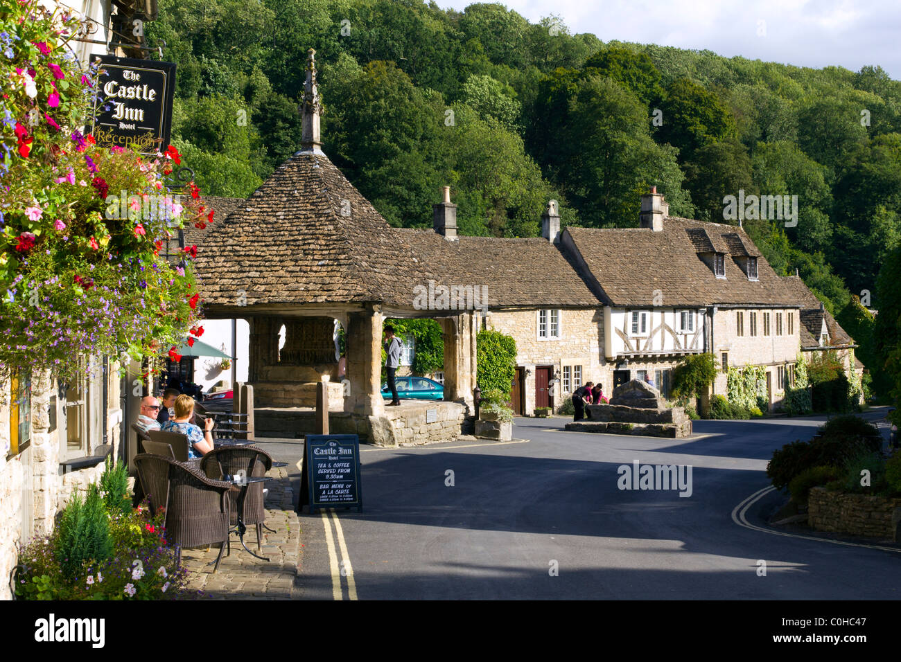 An idyllic Cotswolds street scene on a summer afternoon in Castle Combe ...