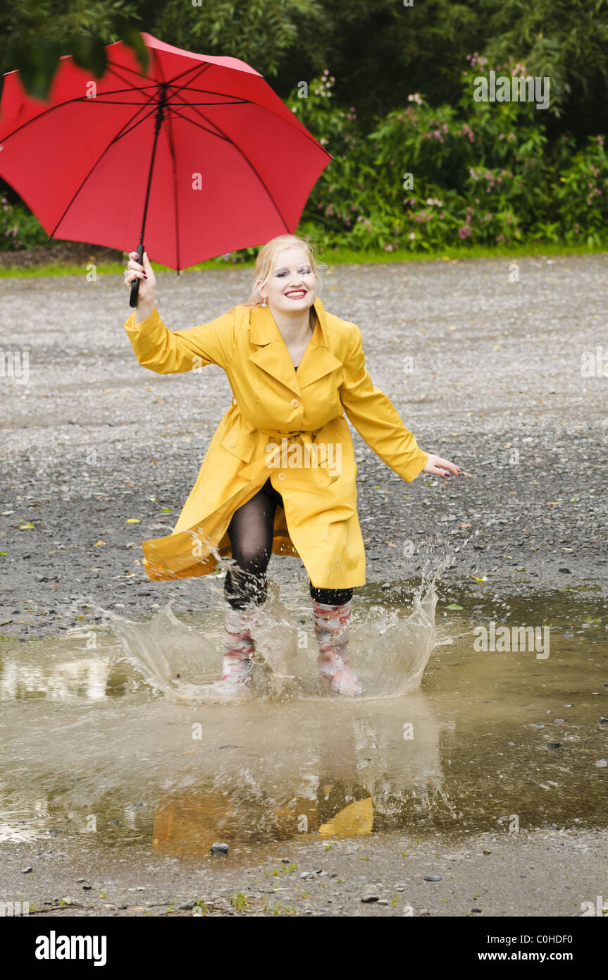 Pretty young woman jumping in the rain Stock Photo - Alamy