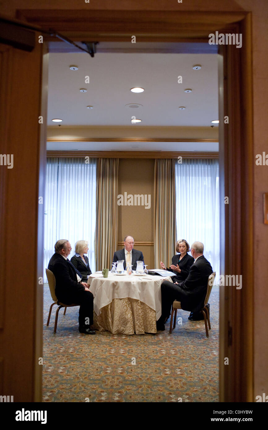 Male and female business executives eat lunch during break from board ...
