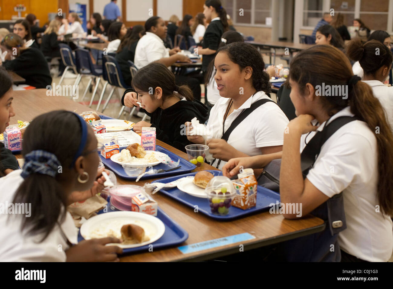 Middle school girls socialize during lunch in the cafeteria at the Ann ...