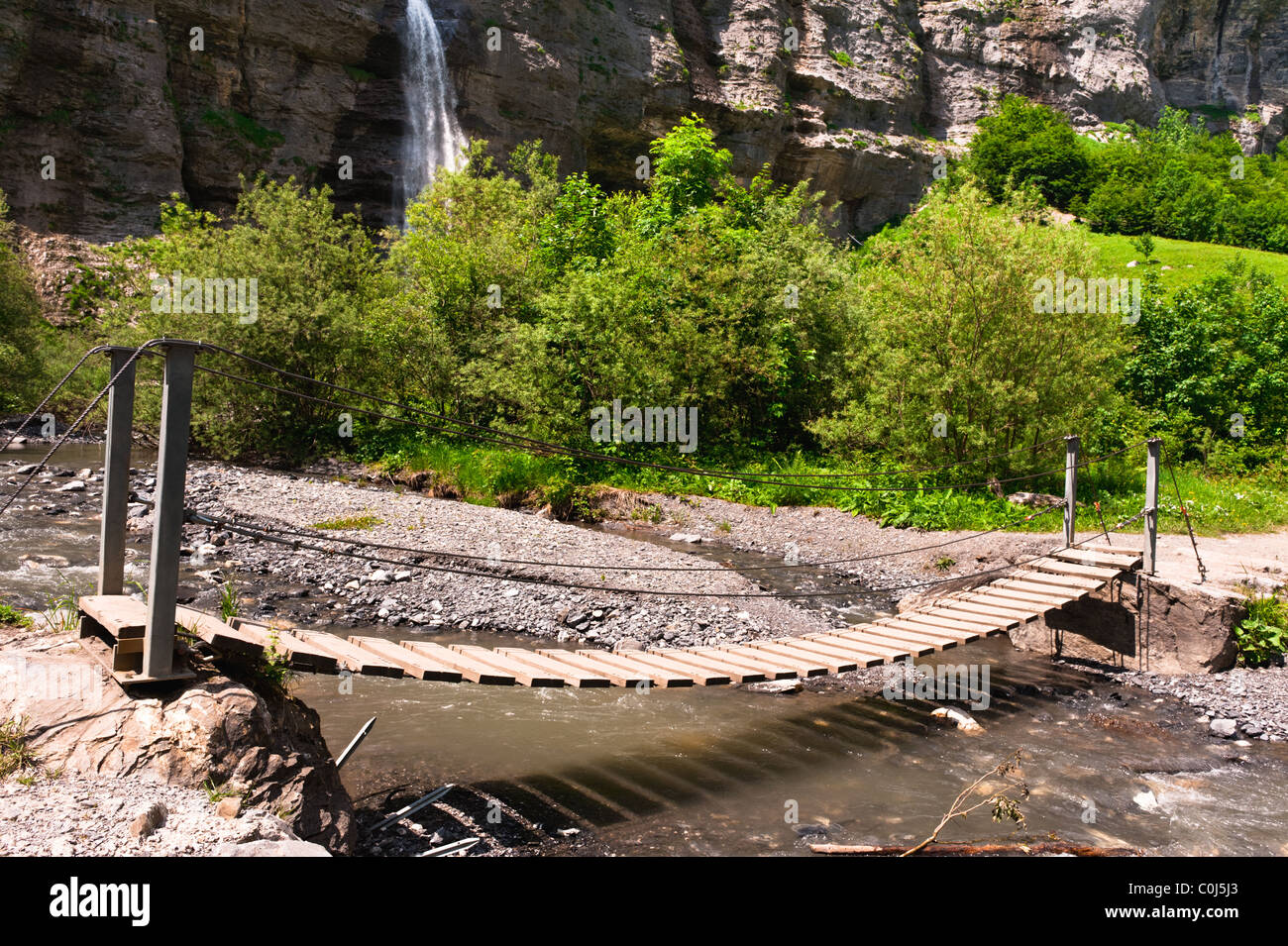 Hanging wooden bridge over mountain river in Sixt Fer a Cheval national ...