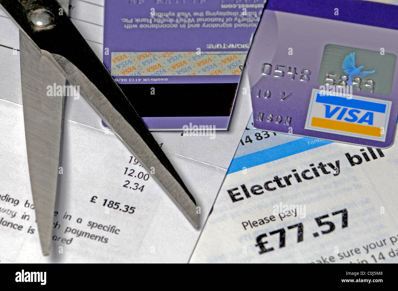 Cut-up credit card, bills and scissors Stock Photo - Alamy