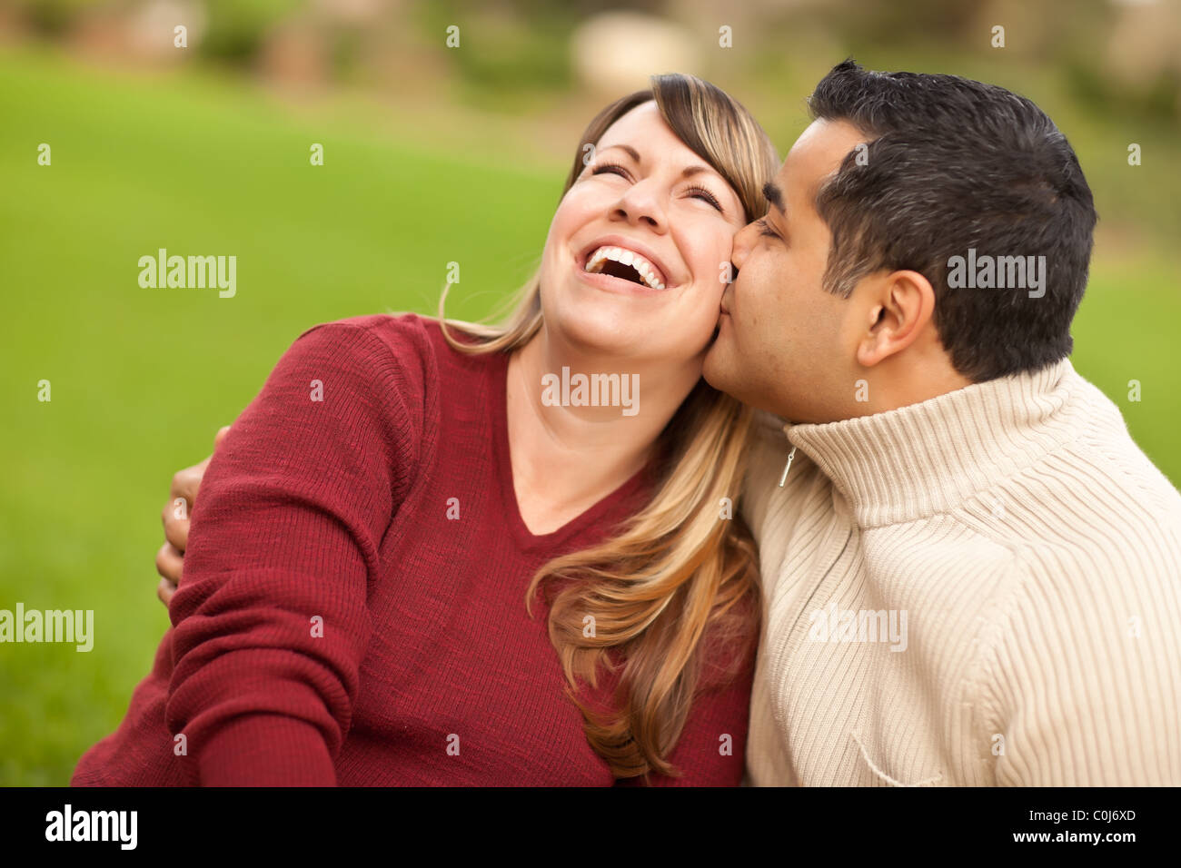 Attractive Mixed Race Couple Snuggle in the Park Stock Photo - Alamy