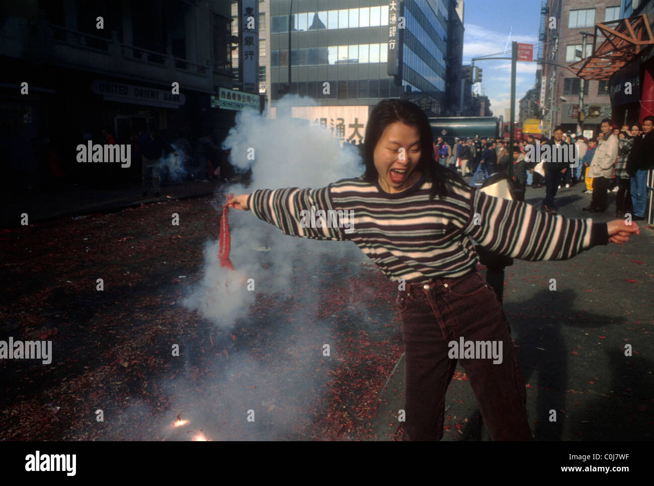 A young woman holds a string of firecrackers on Mott Street in ...