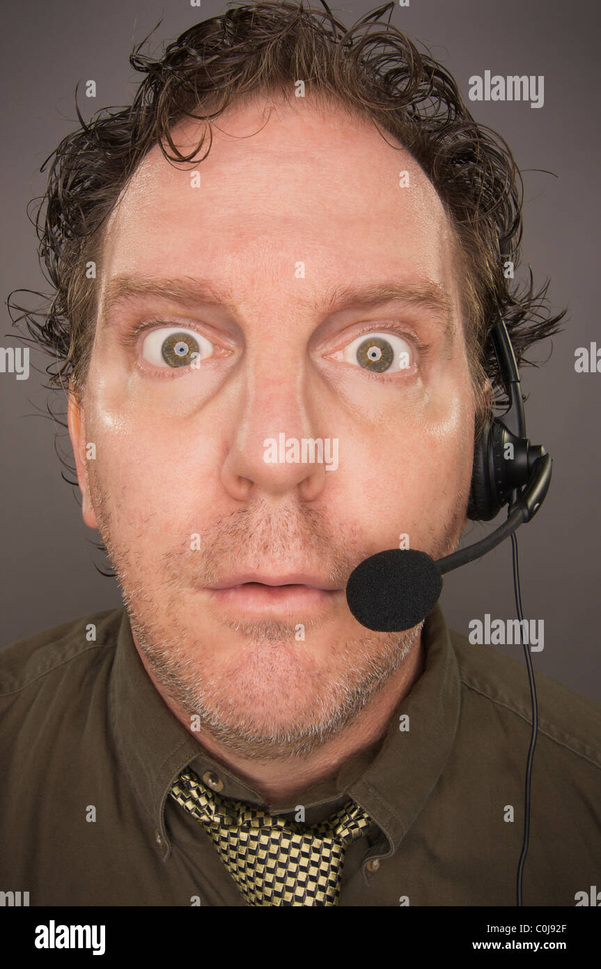 Stunned Businessman Wearing Phone Headset Against a Grey Background ...