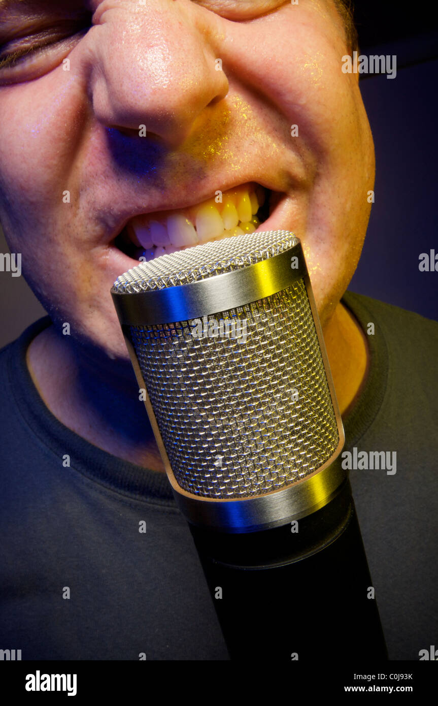 Male Vocalist Sings into a Microphone Stock Photo - Alamy