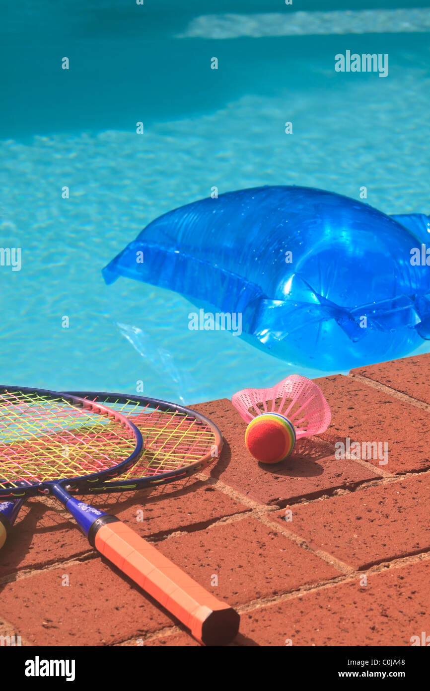 Swimming pool with blue lilo and a garden badminton set Stock Photo - Alamy