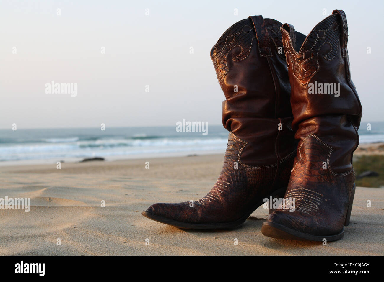 Designer Italian boots on the beach at sunrise Stock Photo - Alamy