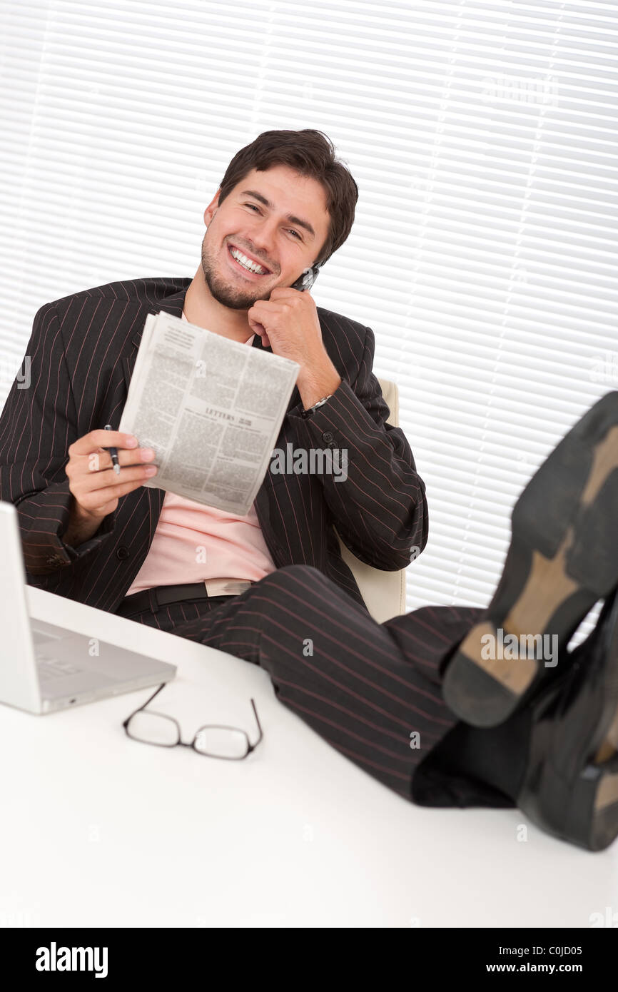 Successful businessman on the phone with legs up Stock Photo - Alamy