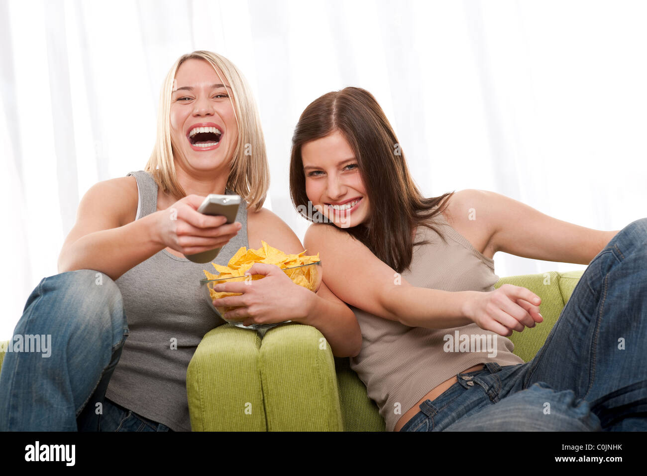 Two teenage girls having fun by television Stock Photo - Alamy