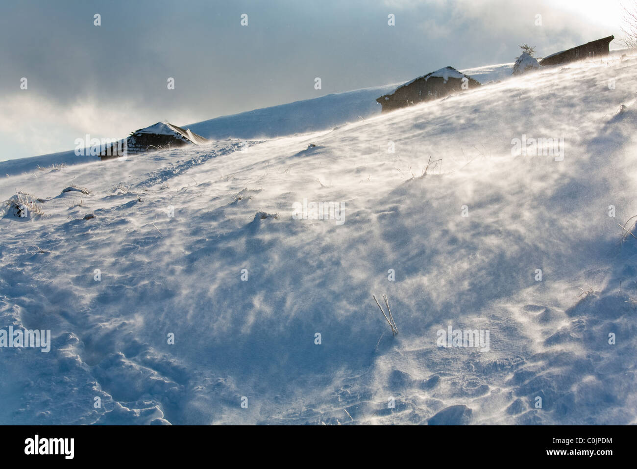 Winter snowy and windy mountain overcast view with sheds behind Stock ...