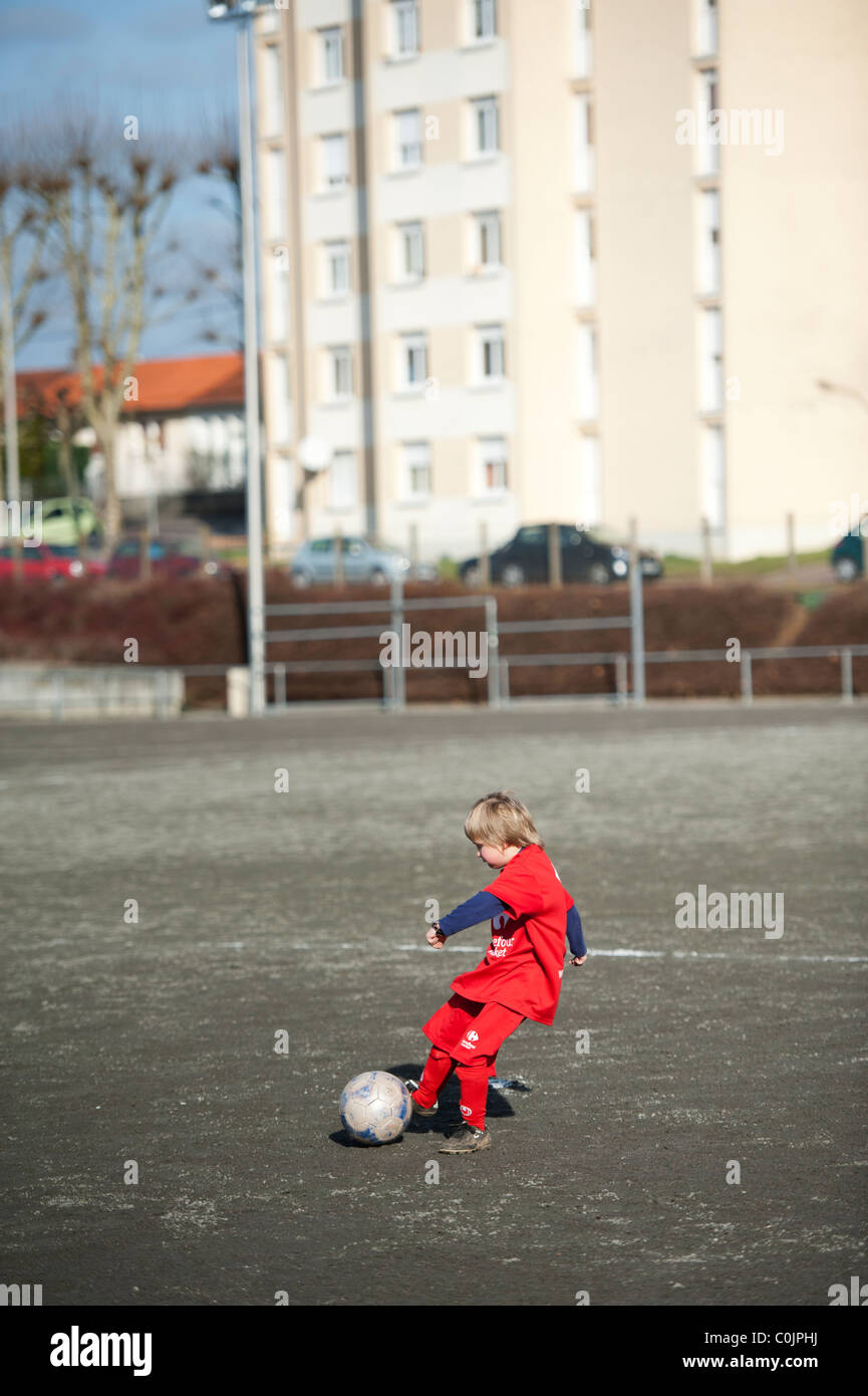Stock photo of children playing football on a sand pitch in an inner ...