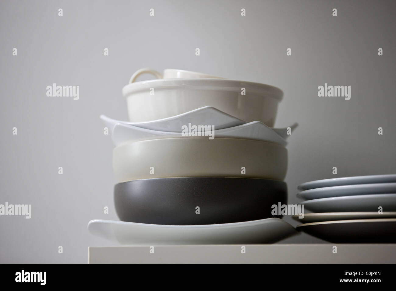 Bowls, plates and a cup stacked on a shelf Stock Photo - Alamy