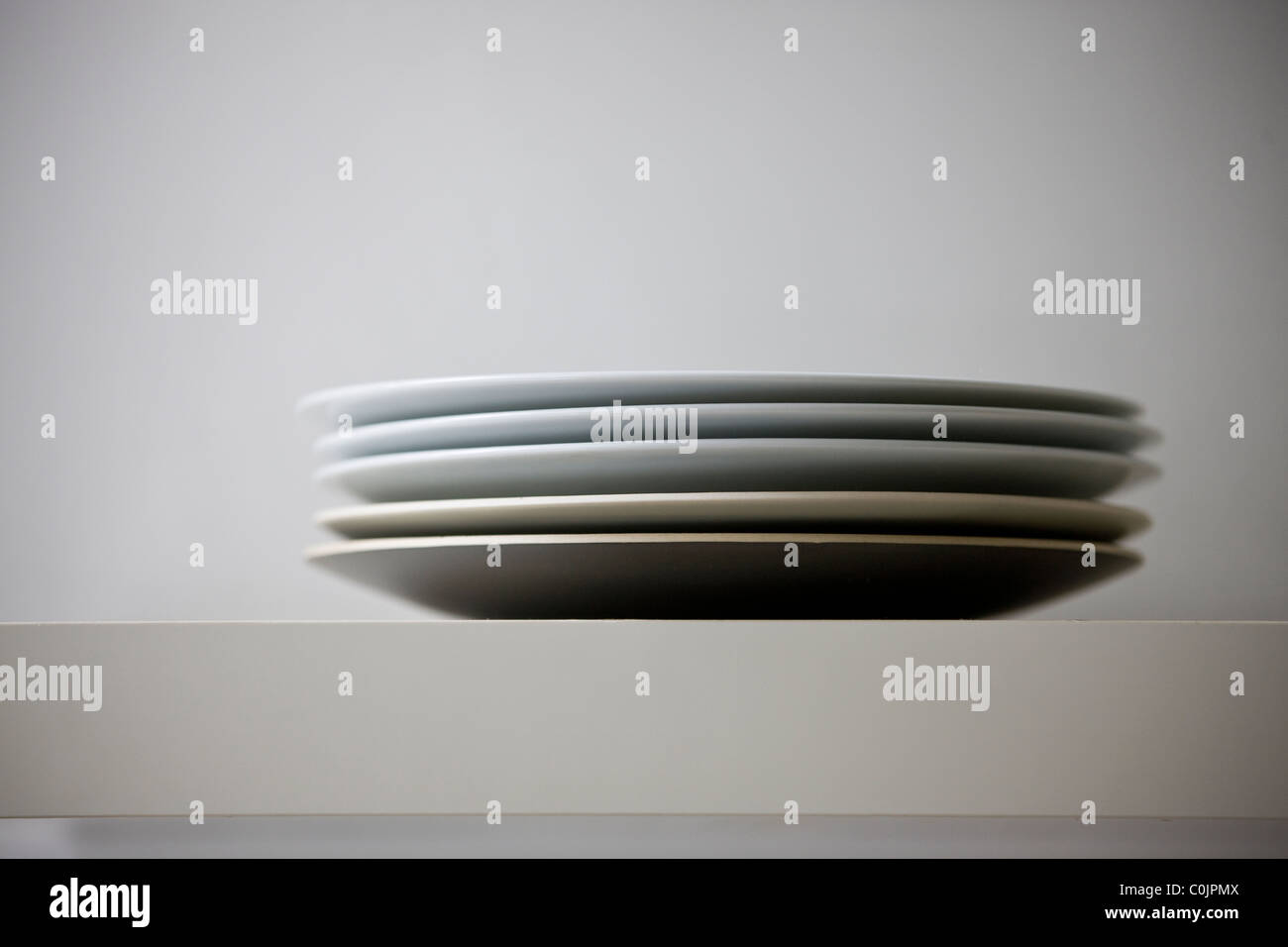 A pile of plates on a shelf Stock Photo - Alamy