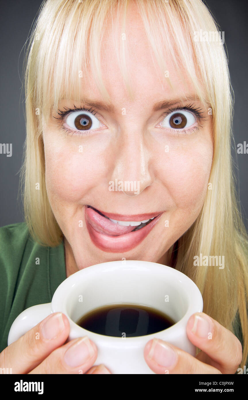 Silly Woman Enjoys Her Coffee Against a Grey Background Stock Photo - Alamy