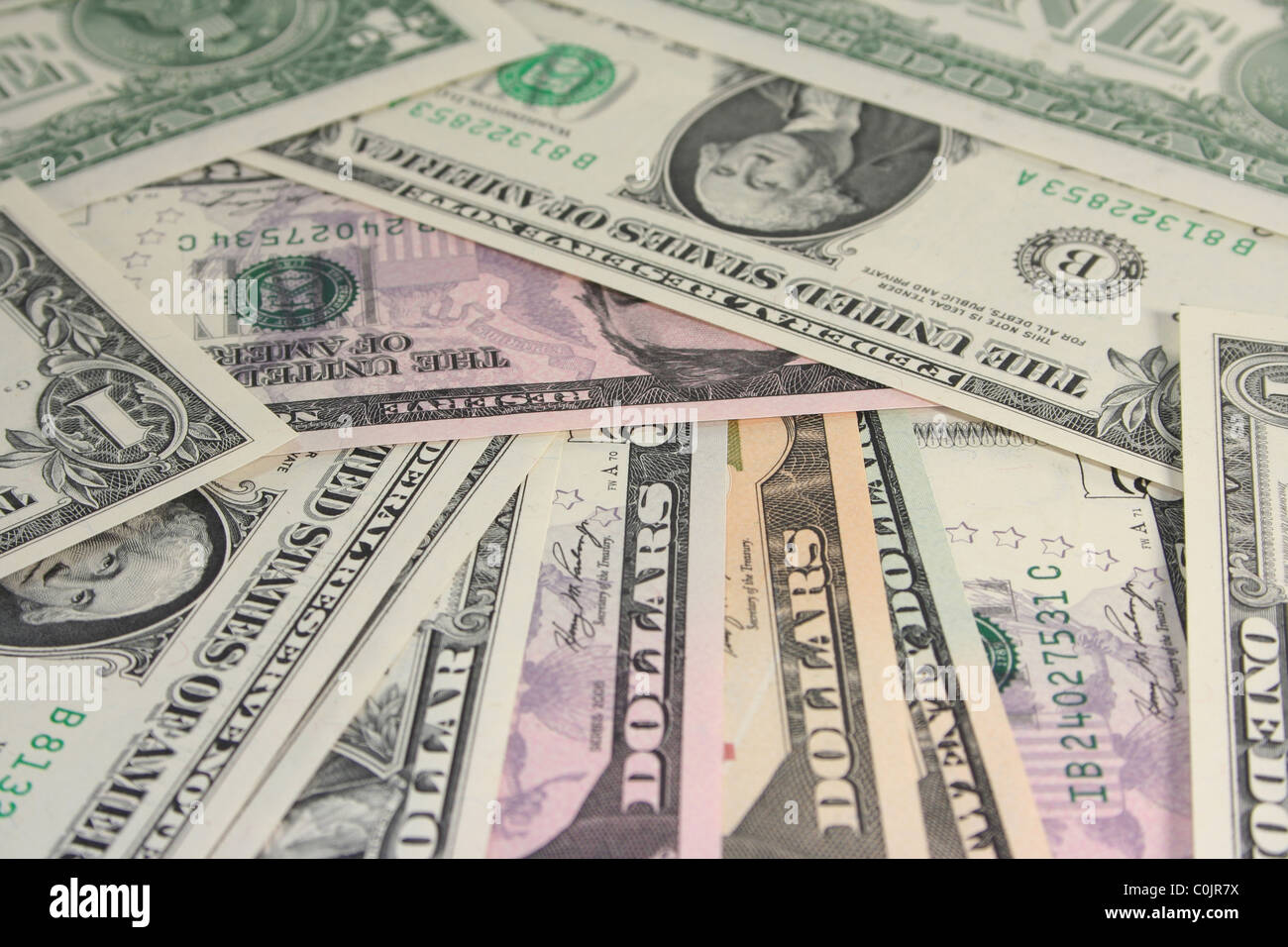 a pile of dollar bills in front of white background Stock Photo - Alamy