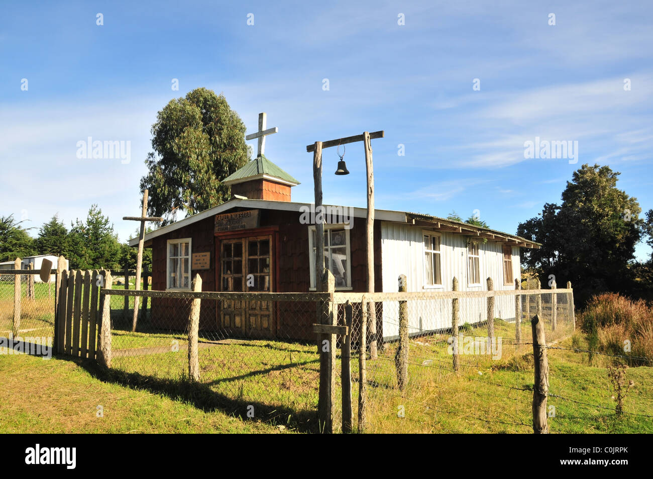 Blue sky green grass rural view of the small wooden chapel of Our Lady ...