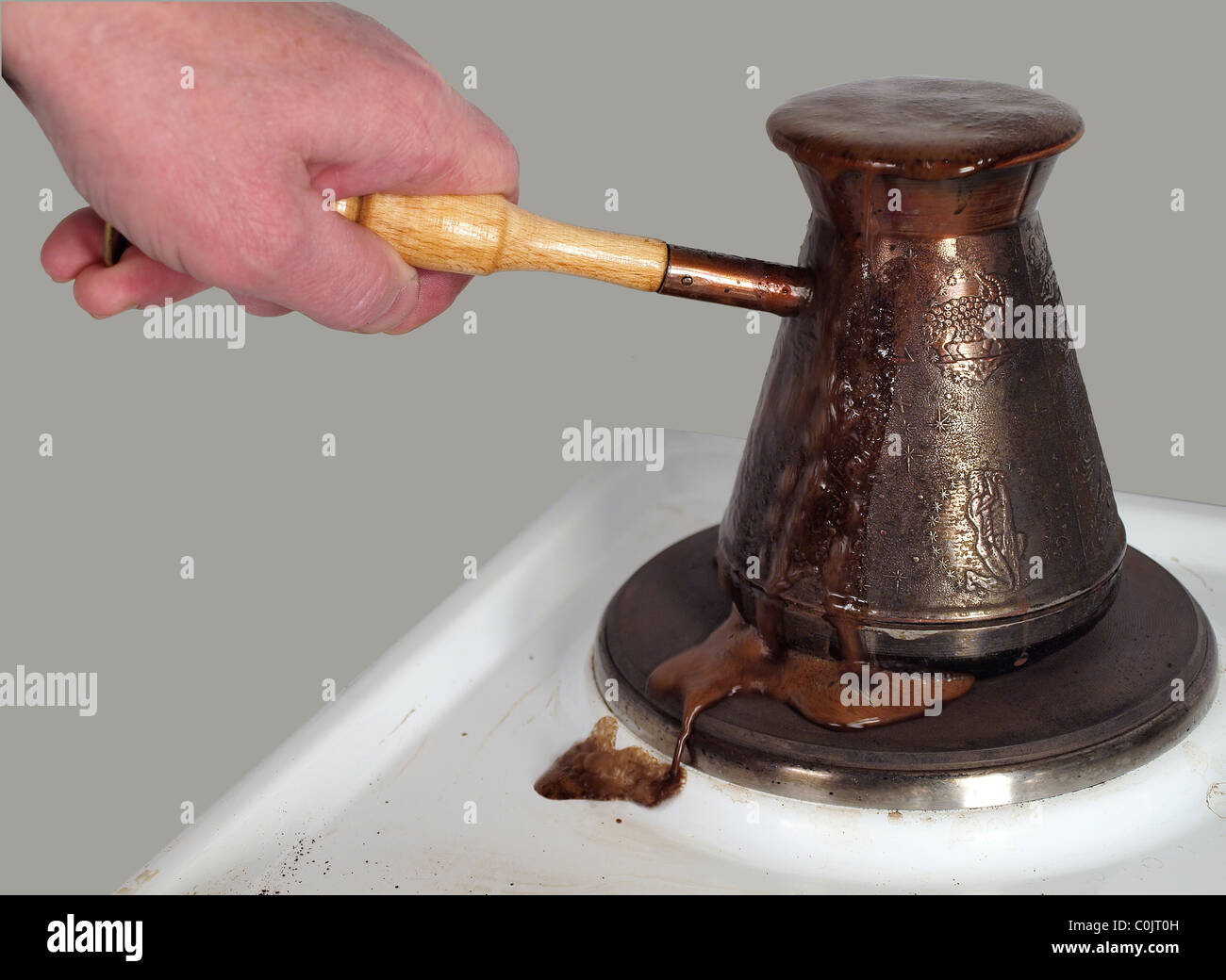 Hand holding coffee maker with boiling coffee on electric burner Stock ...