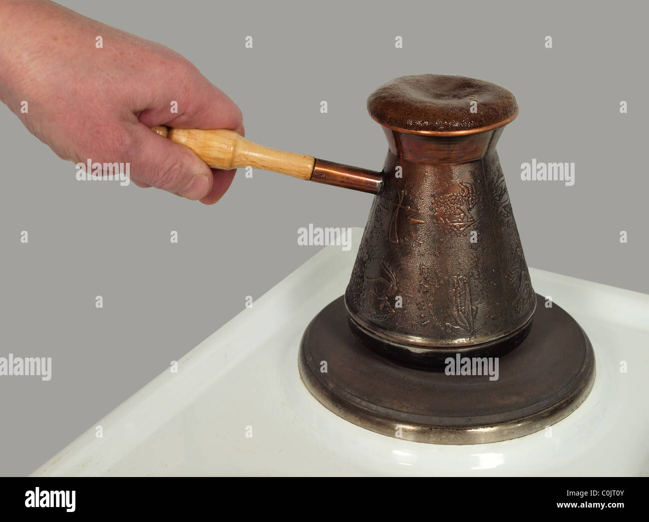 Hand holding coffee maker with boiling coffee on electric burner Stock ...