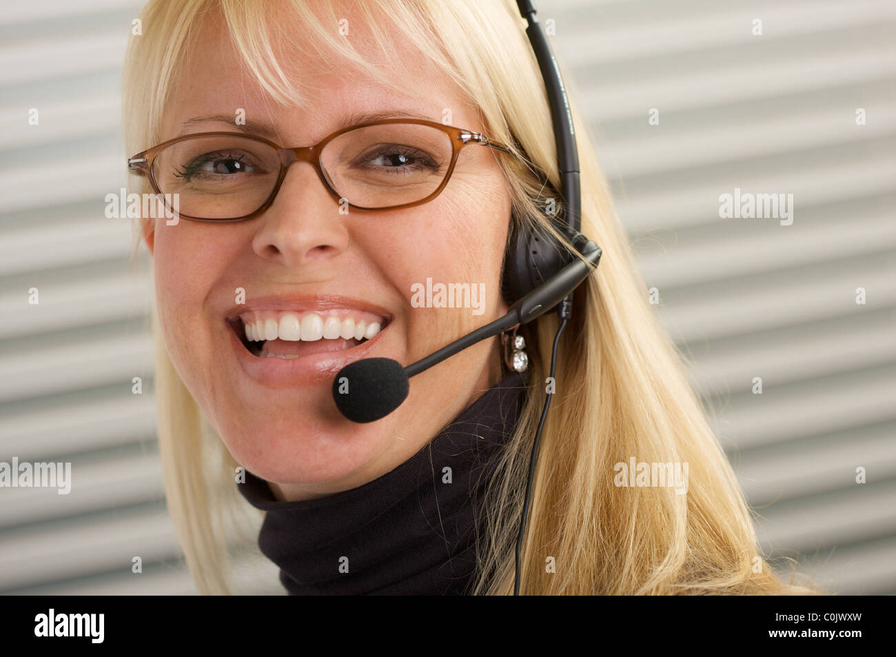 Smiling Customer Service Rep smiles as she talks on her phone headset ...