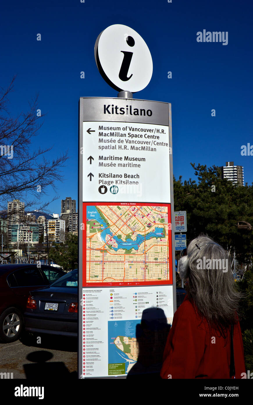 Woman red coat looking at Kitsilano Vancouver Map tourist information ...